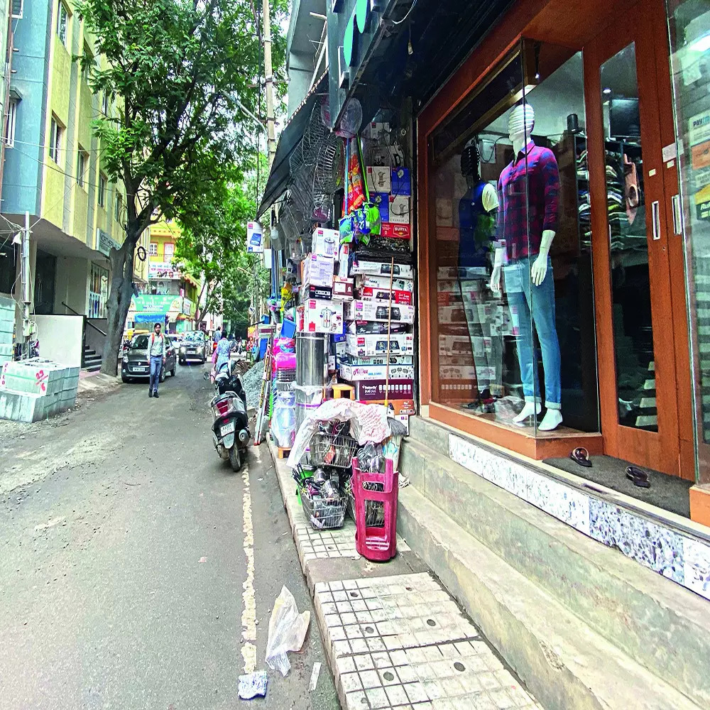 Business on footpath, pedestrians on road