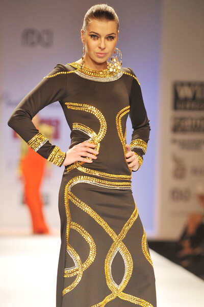 A model walks the ramp to showcase a creation by designer Preeti ...