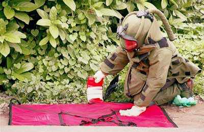 A Bomb Diffusal Squad personnel engaged in diffusing a live bomb near ...