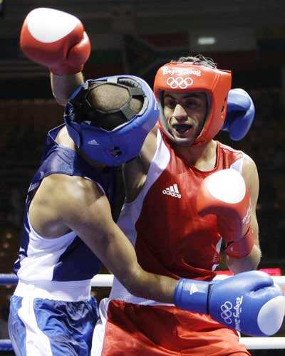 Akhil Kumar of India celebrates his victory over Ali Hallab of France ...
