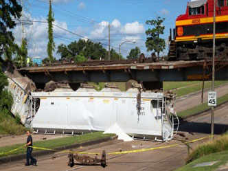 Derailed freight train falls from bridge onto highway