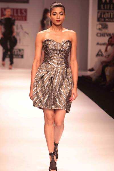 A model presents a creation by designer Narendra Kumar on Day 1 of ...