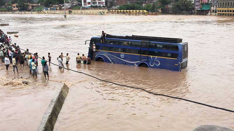 Watch: Tourist bus stuck in floodwaters pulled out with a rope