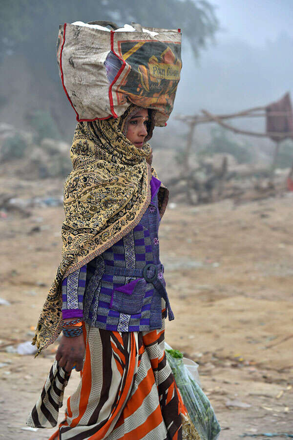 A labourer heads for work on a cold and foggy morning in New Delhi ...