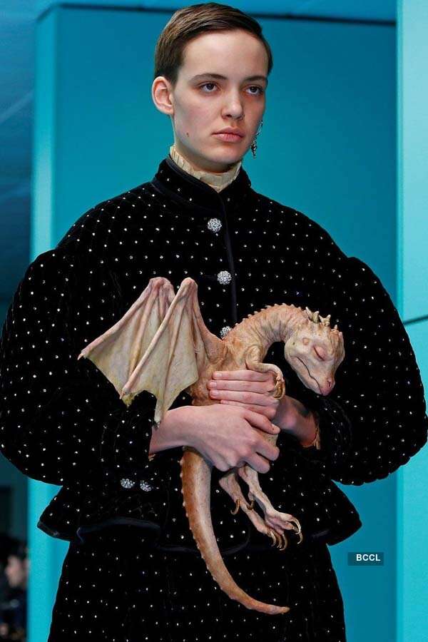 Models carry fake heads on the ramp