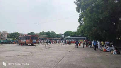 Passengers wait for buses in rain after collapse of a section of MSRTC ...