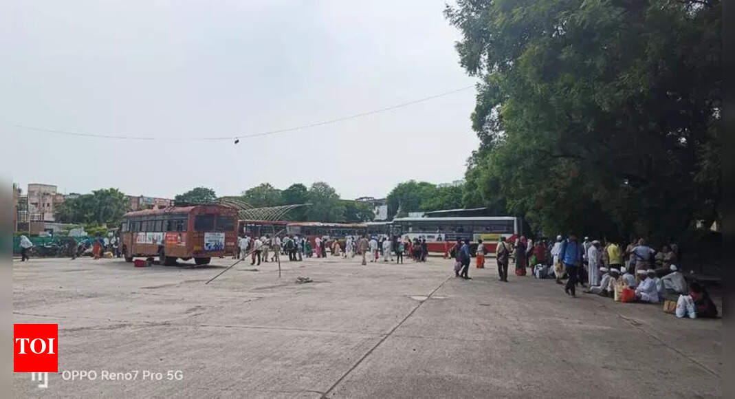 Passengers wait for buses in rain after collapse of a section of MSRTC ...