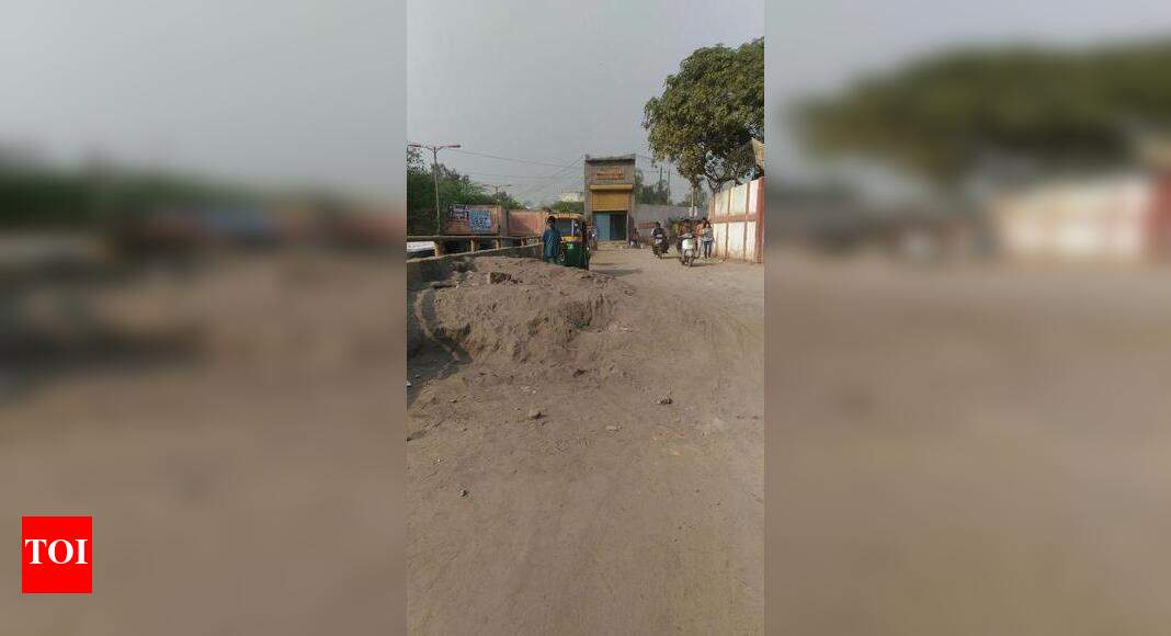 Road dug up, construction material dumped - Times of India