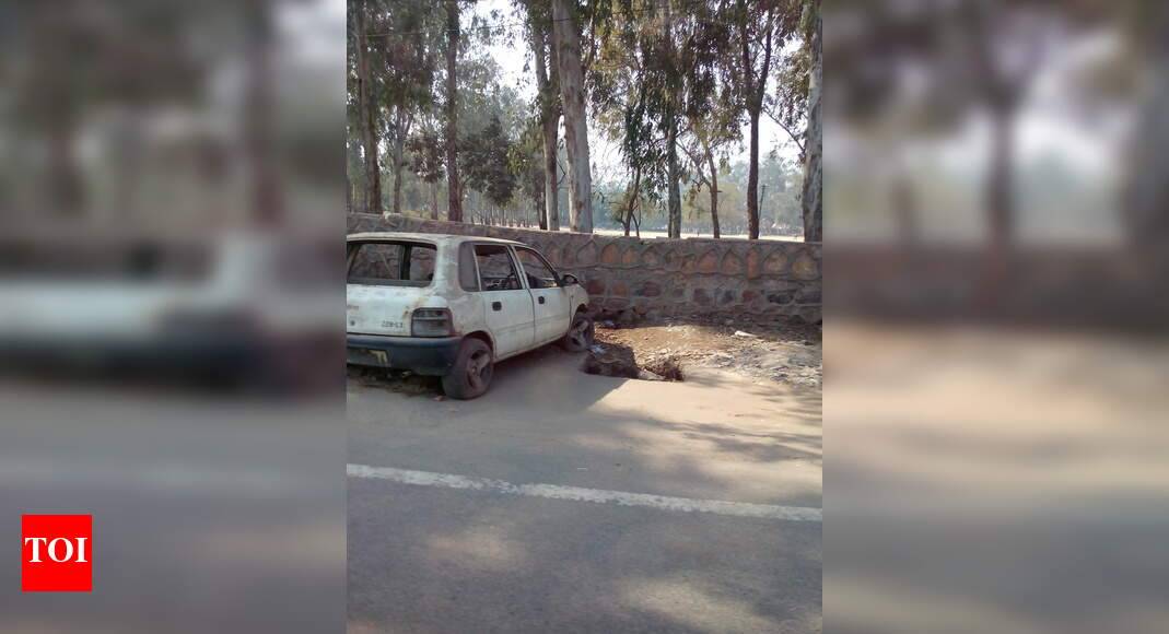 Abandoned car and open manhole - Times of India