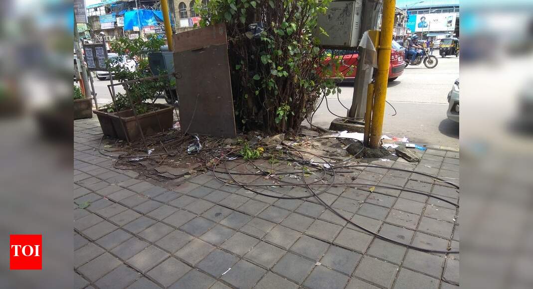 Cables scattered on foot path - Times of India