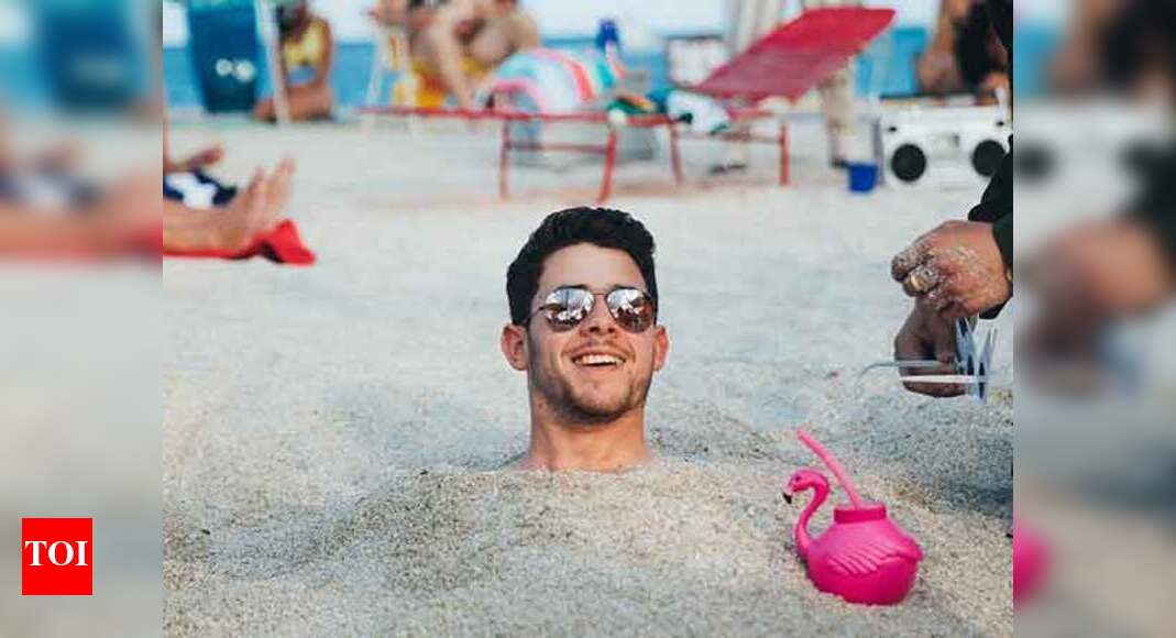 Nick Jonas shares cute picture ‘neck-deep’ in the sand | English Movie ...