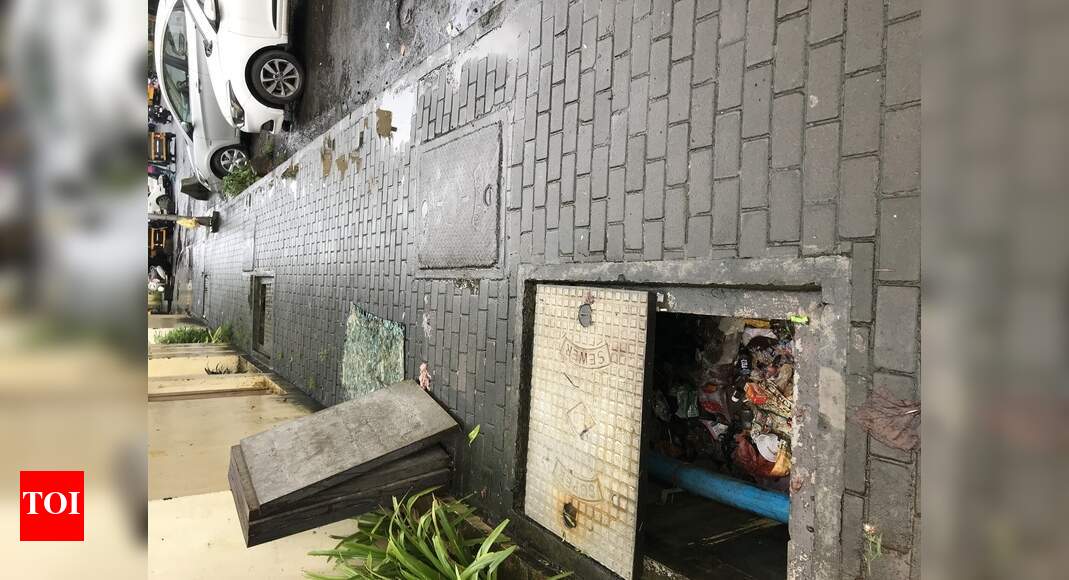 Footpath unused due to missing manhole covers - Times of India