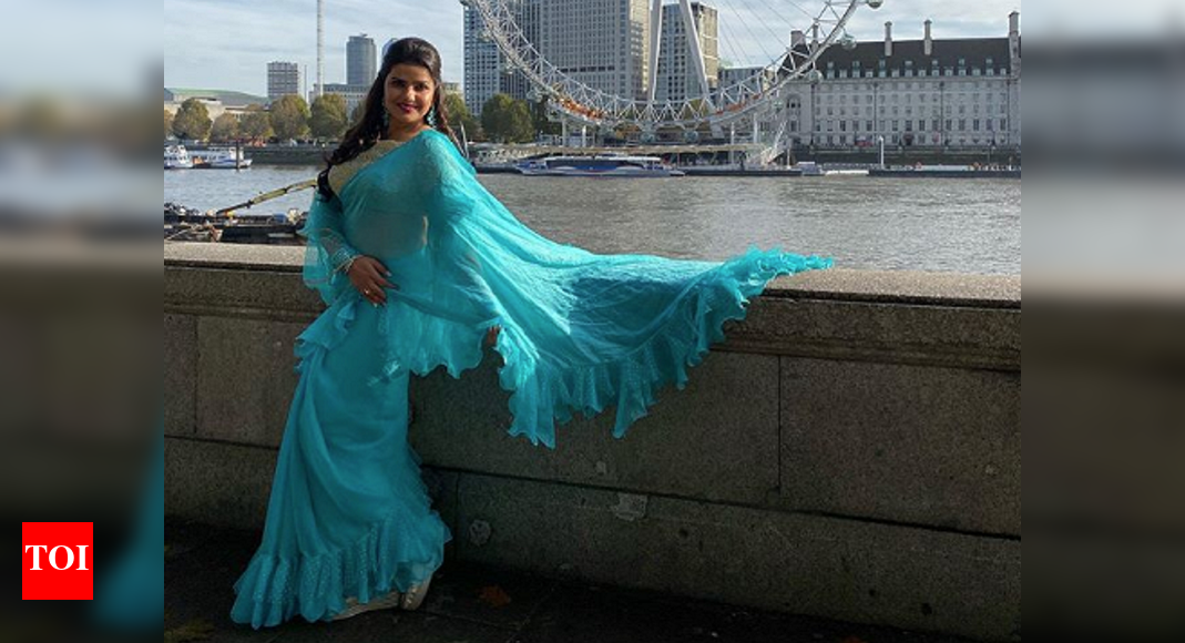 Madhu Sharma poses in front of the London Eye in a sky blue saree ...