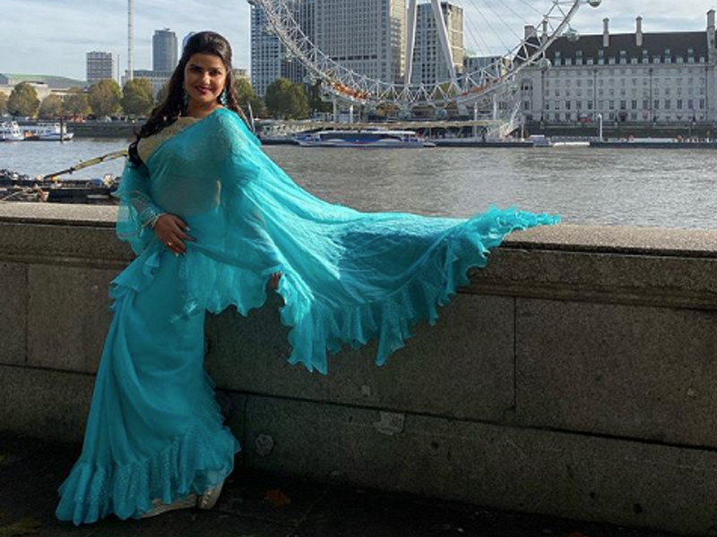 Madhu Sharma poses in front of the London Eye in a sky blue saree ...