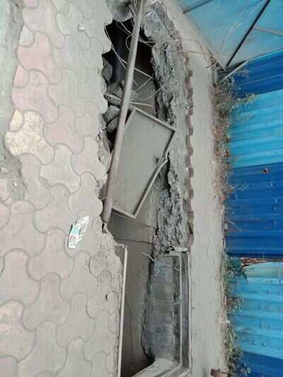 broken footpath with massive holes - Times of India