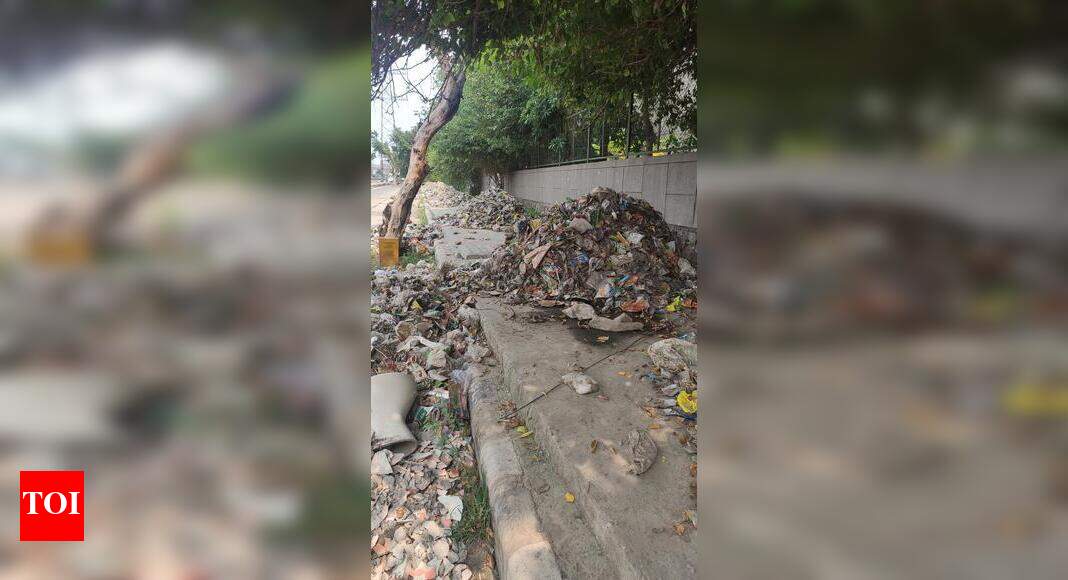 Sewer silt lying on footpath - Times of India